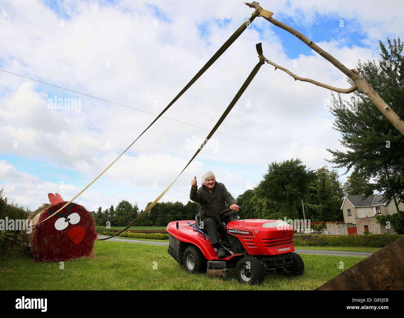 Billy Barry cuts the grass beside an 'Angry Birds' scarecrow during the ...