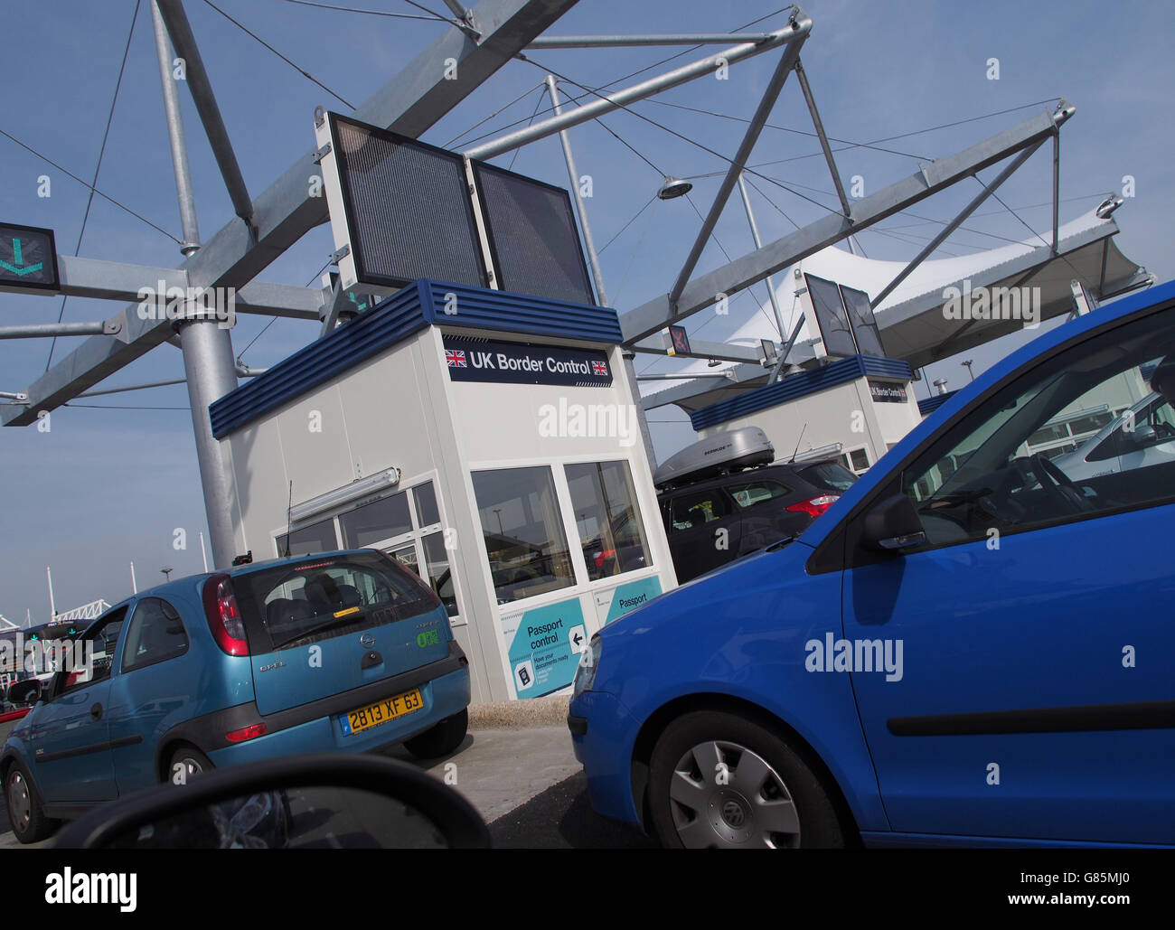 Cars driving through UK Border Control checkpoints at Calais ferry port ...