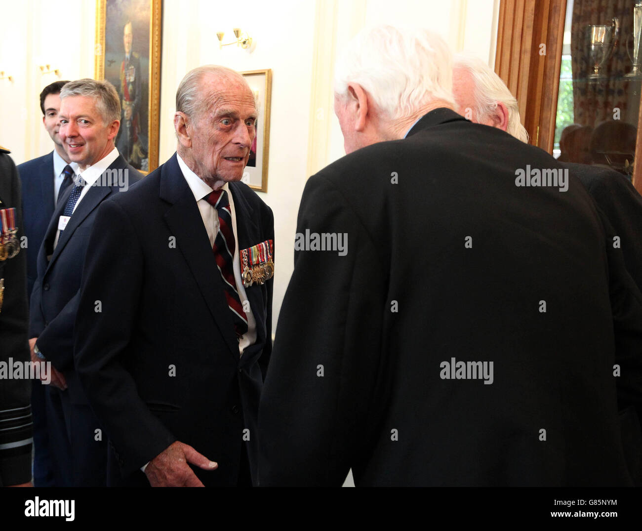 The Duke of Edinburgh is presented a book by Wing Commander Tom Neil ...