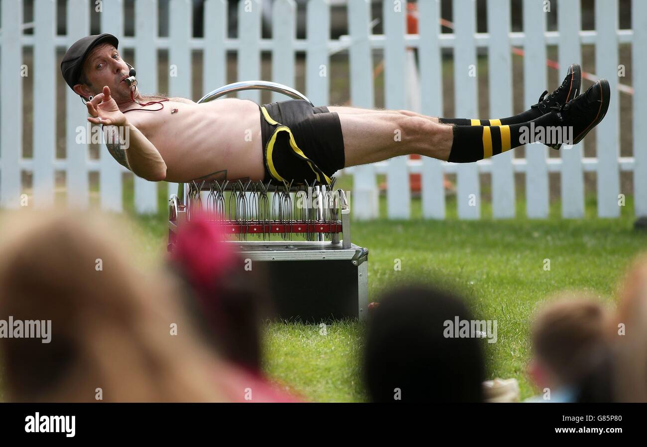 Street performer Shep Huntly lies on a bed of forks during the opening ...