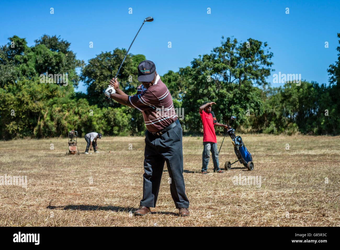 Men play golf at the Royal Livingstone golf club in Zambia. Livingstone ...
