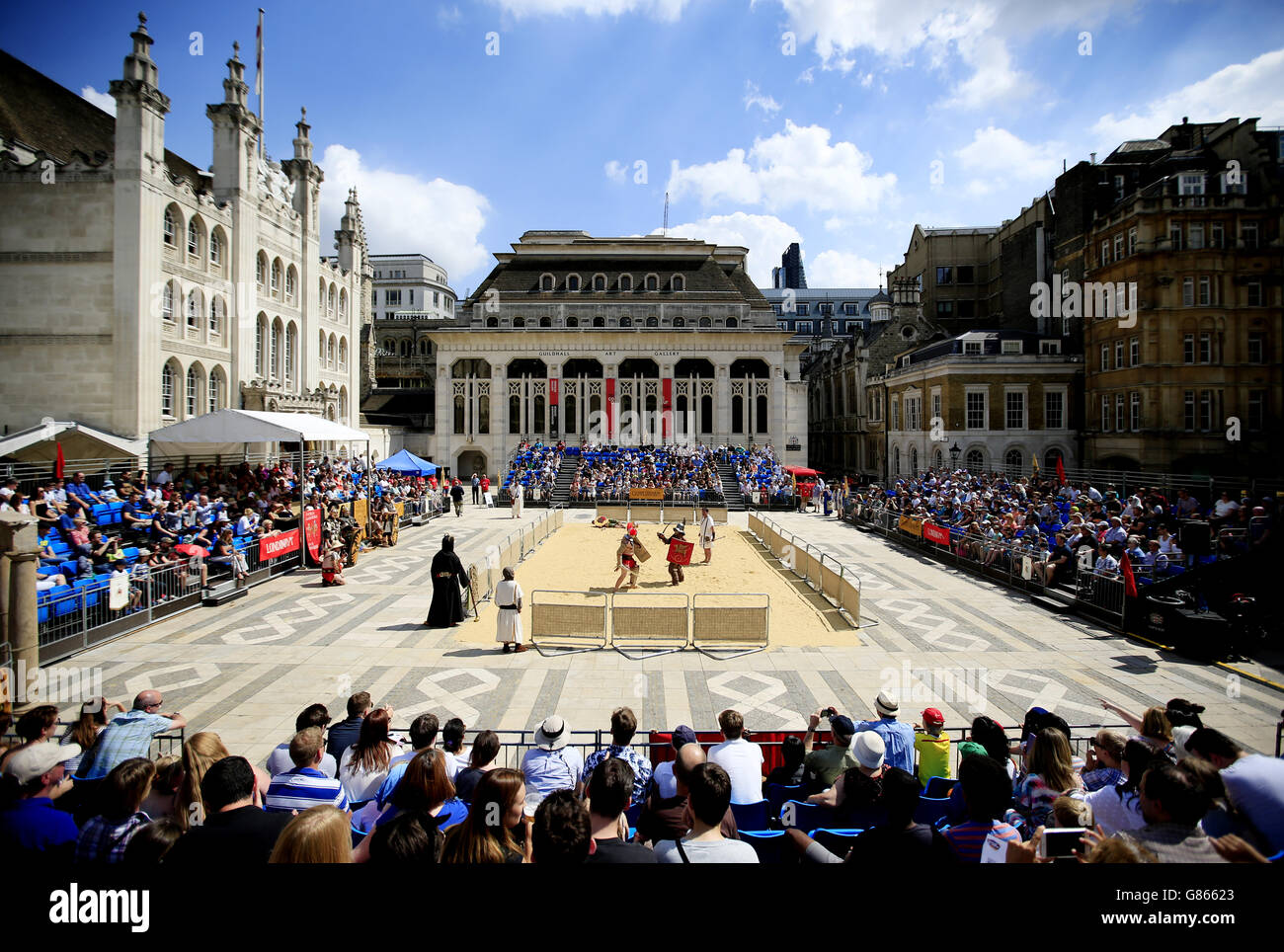 Gladiatorial performers engage in mock combat in front of spectators at ...