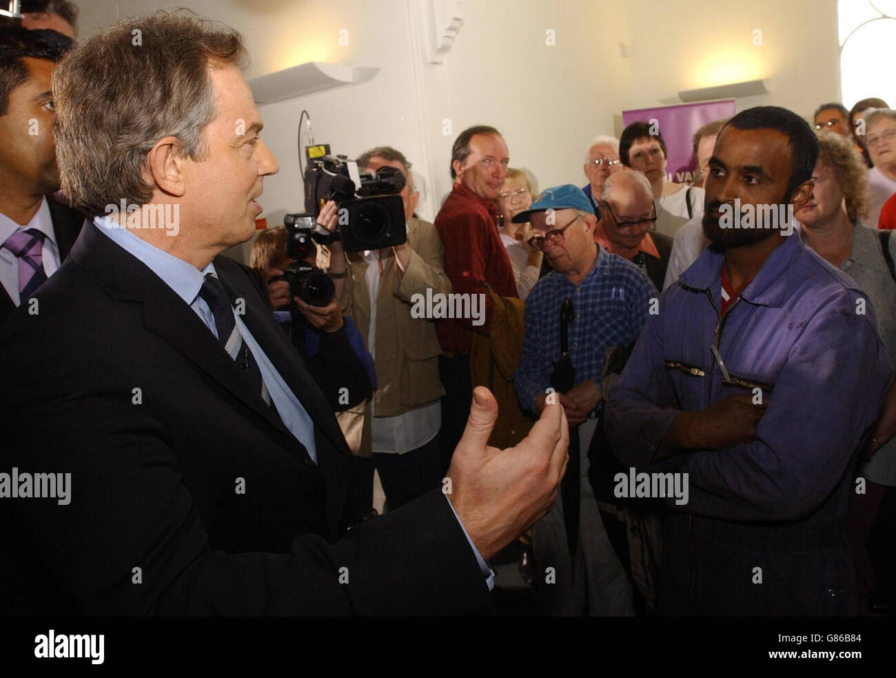 Britain's Prime Minister Tony Blair is confronted by Mohamed Jaffer ...