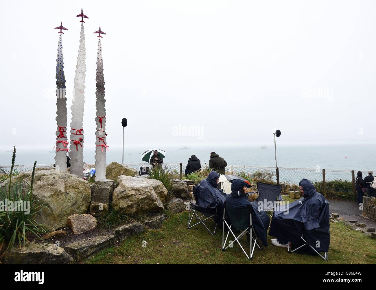 Spectators brave the wind and rain as they sit next to the Jon Egging ...