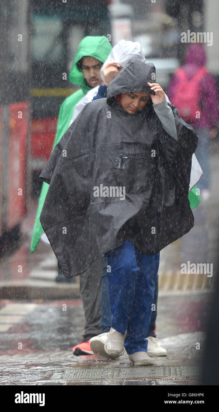 Members of the public get caught in heavy rain in central London Stock ...