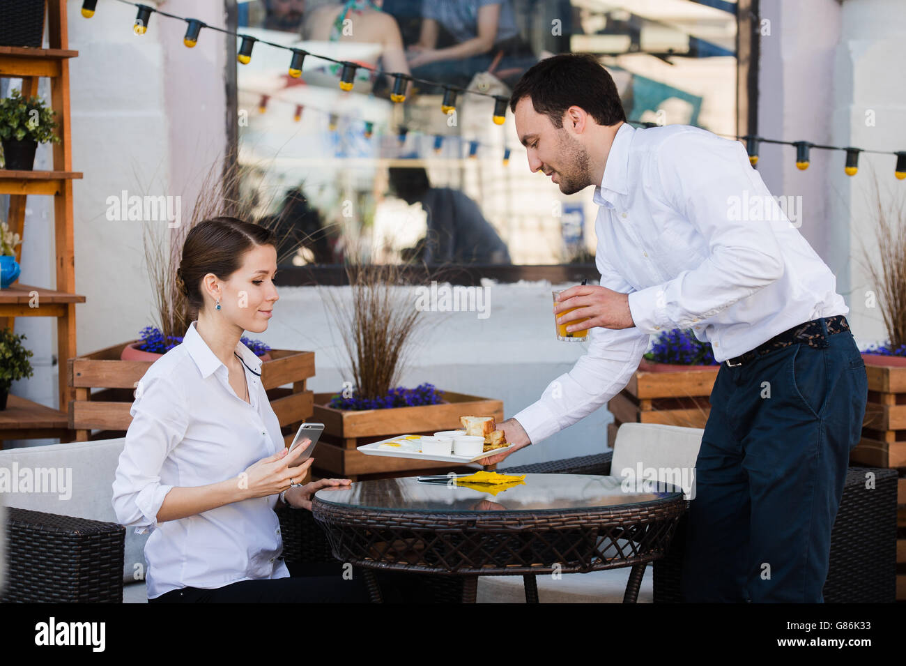 Waiter server at table working reading menu specials list for group of ...