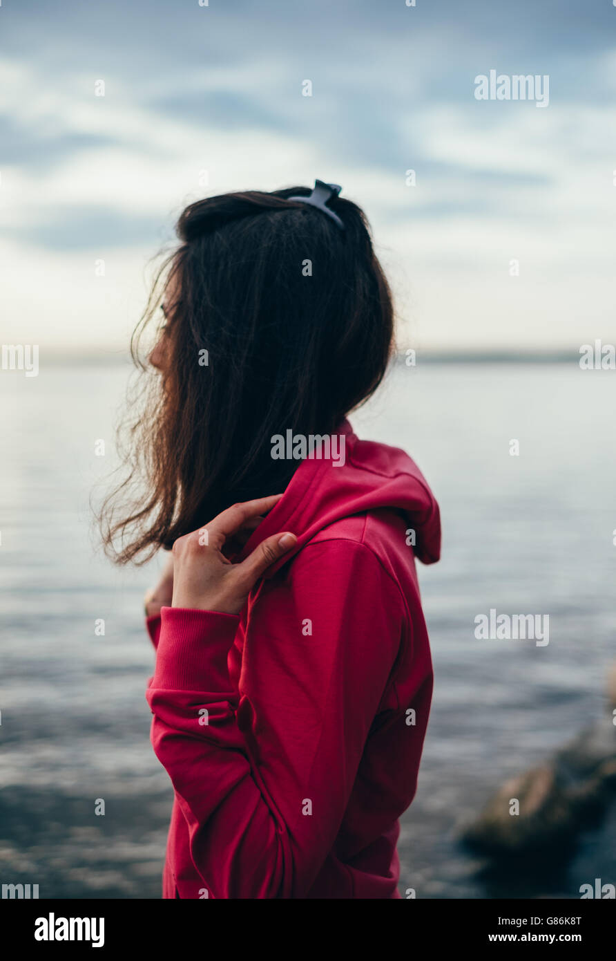 Woman standing by the sea looking at view Stock Photo - Alamy