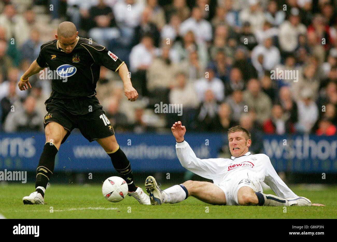 Wigan's Jason Jarrett (L) gets away from Richard Cresswell of Preston ...
