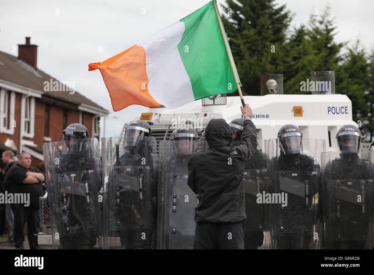 A nationalist protester waves an Irish Tricolour in front of PSNI ...