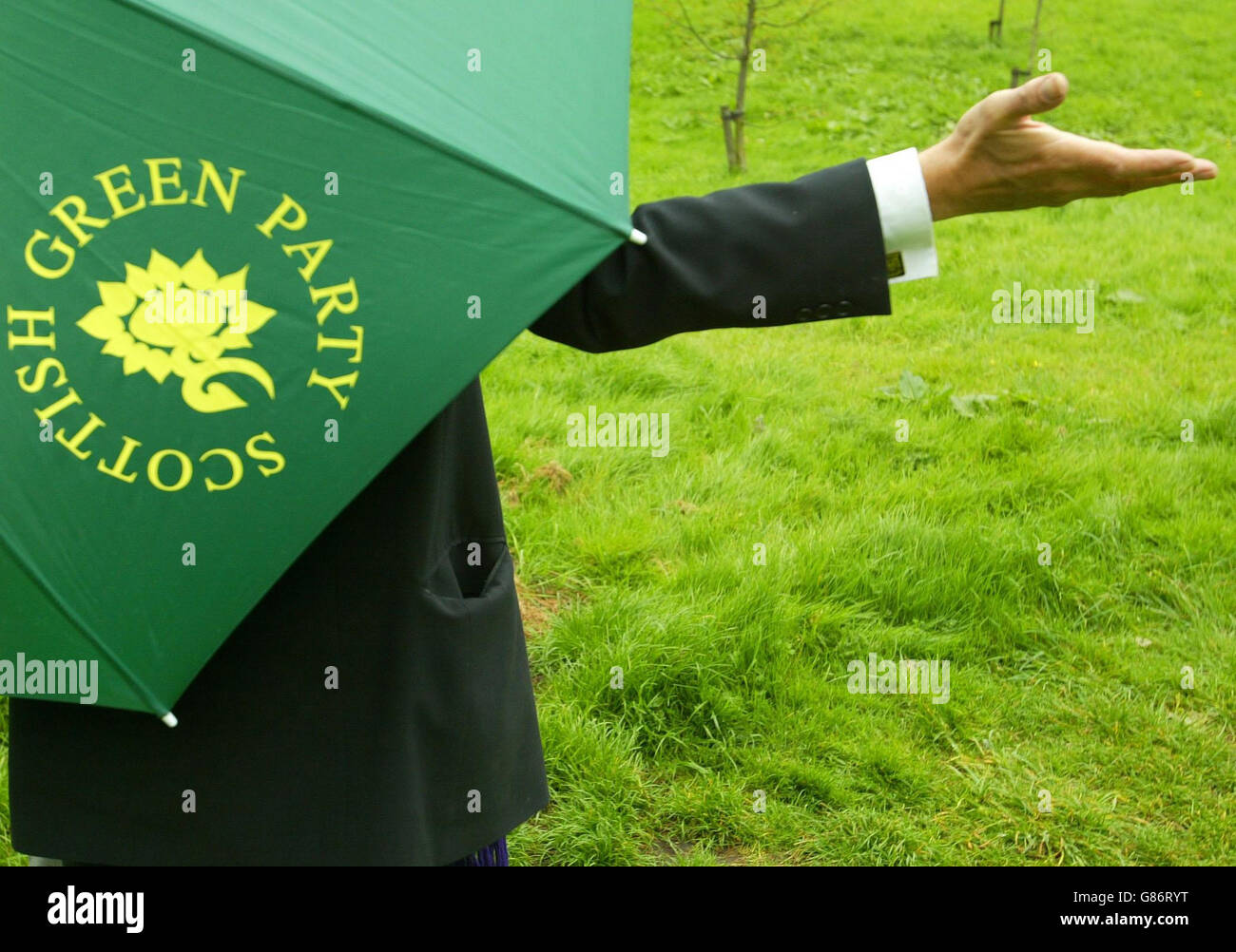 Scottish Green party Co-convener Robin Harper shelters under an ...