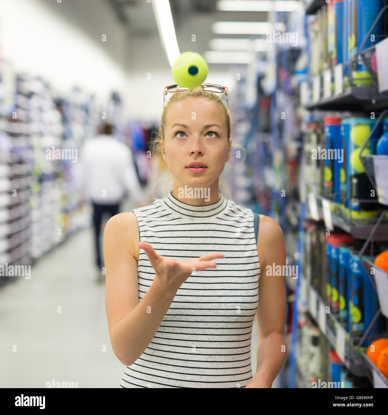 Woman shopping tennis balls in sportswear store Stock Photo - Alamy