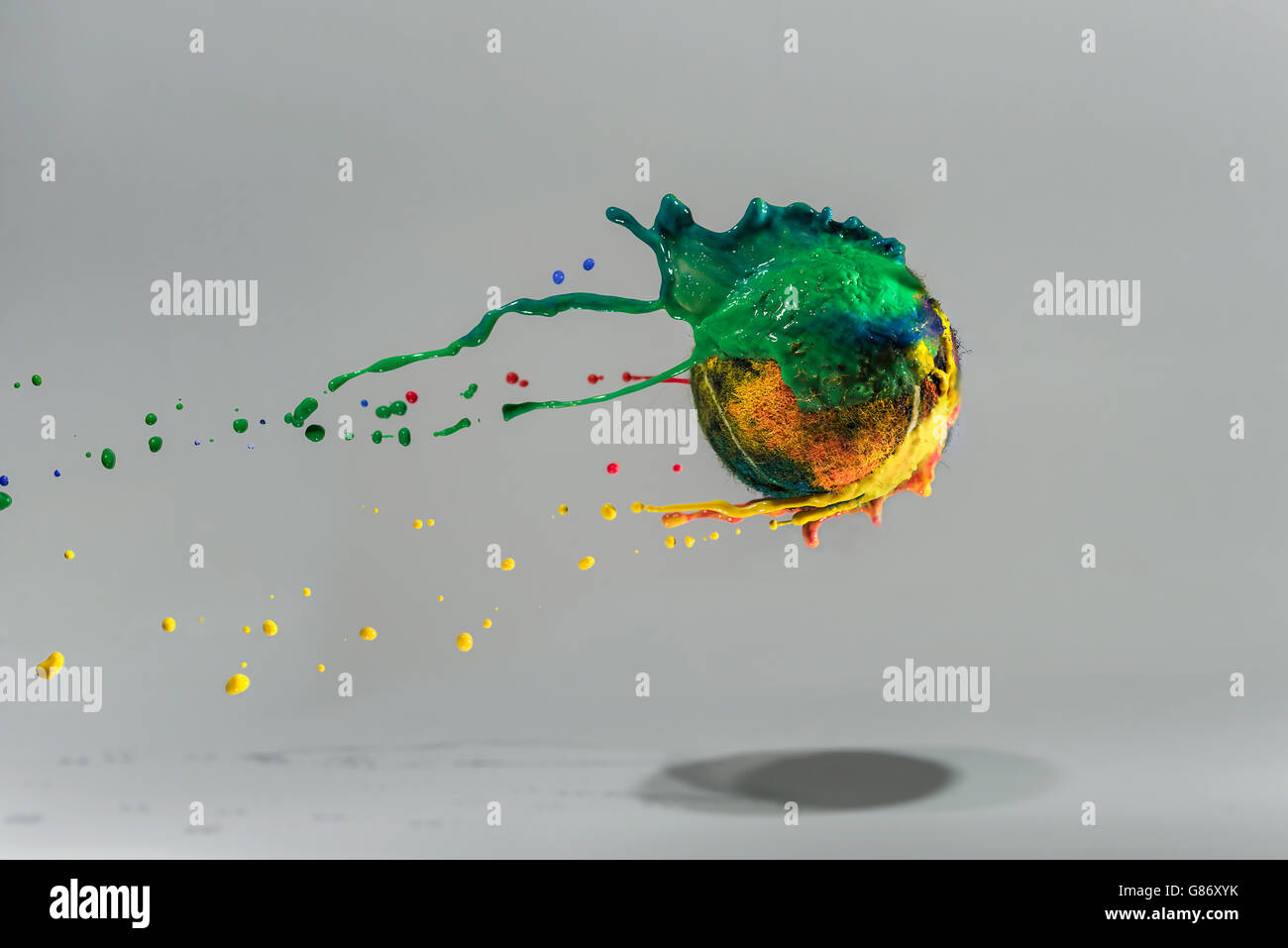 Tennis ball mid air covered in multi coloured acrylic paint Stock Photo ...