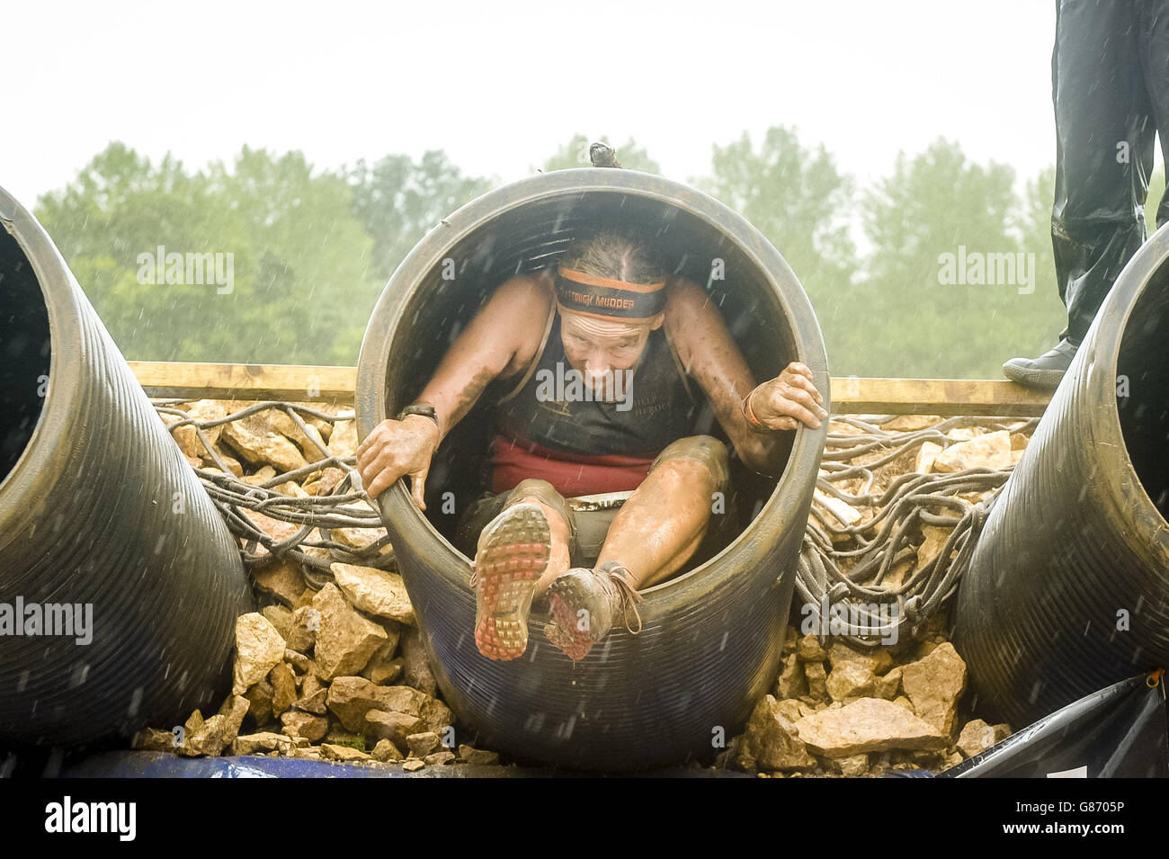 Participants exit huge pipes during a Tough Mudder 12 mile obstacle ...