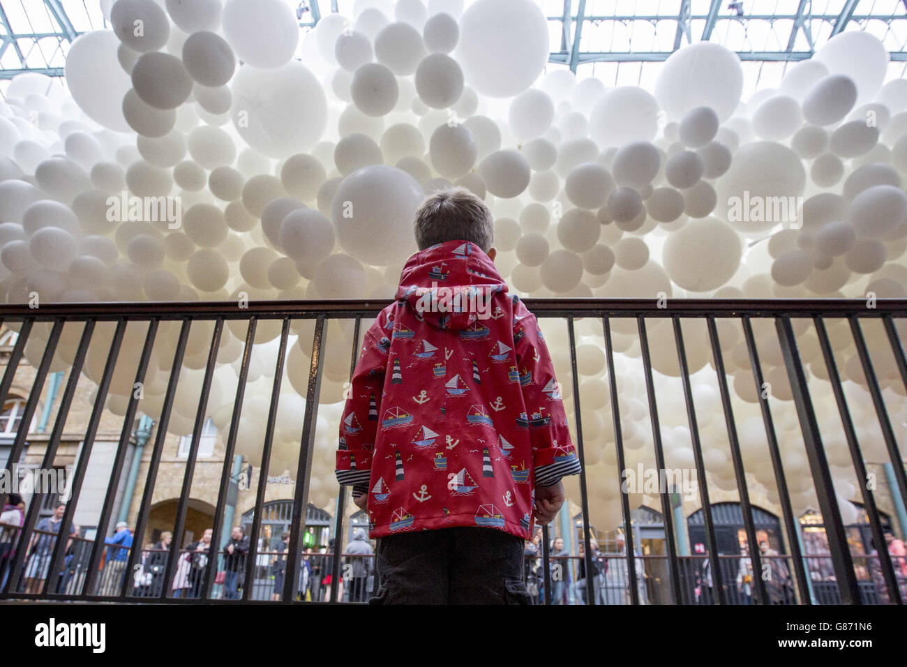 Rory Perry 4, looks up at thousands of white balloons placed in the ...