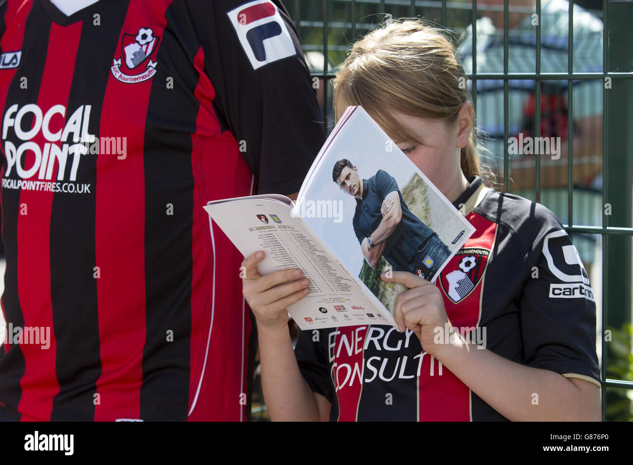 A young AFC Bournemouth fan reads the match day programme outside the ...