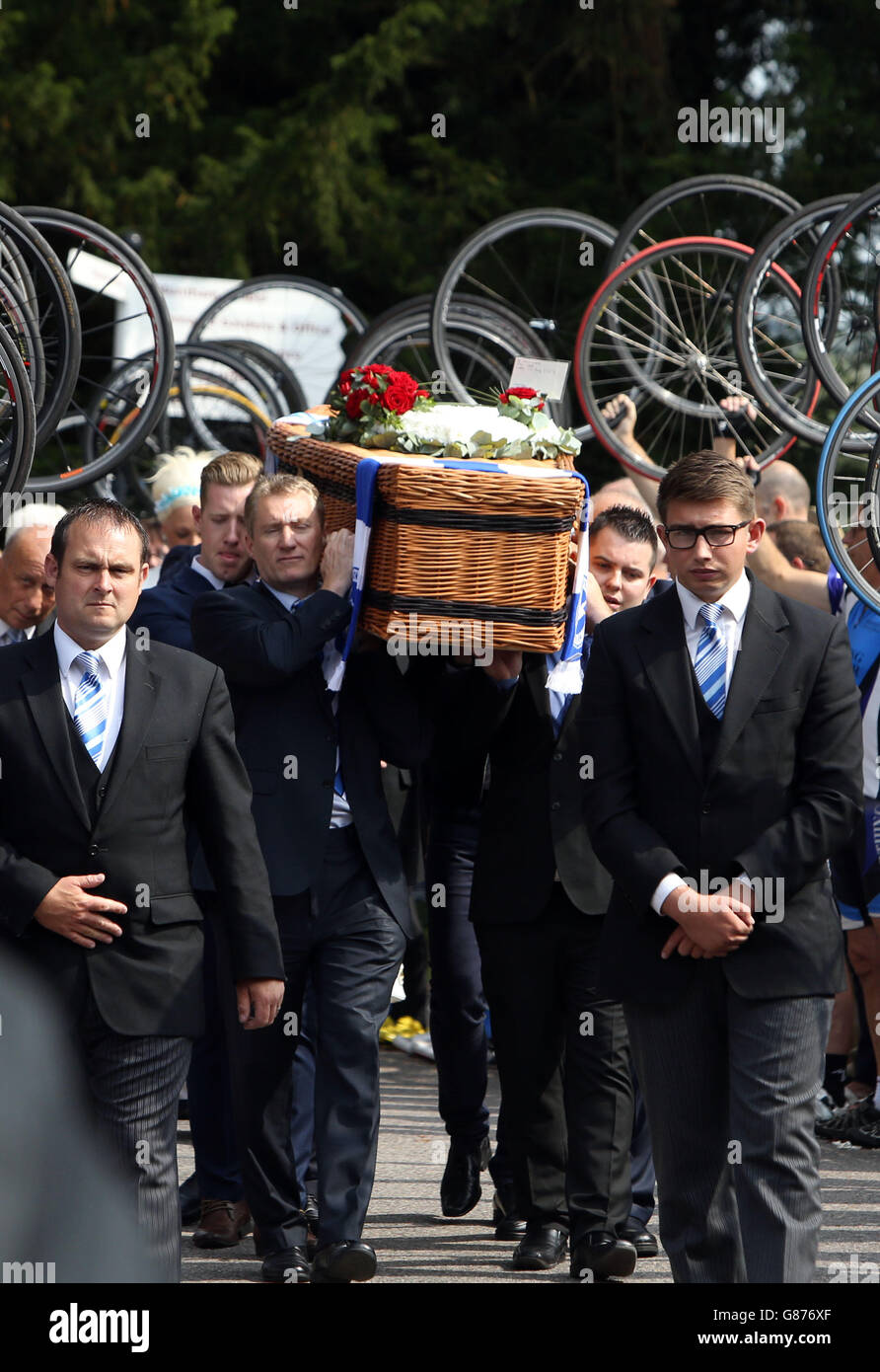 Cyclist perform a guard of honour with their bike wheels as the coffin ...