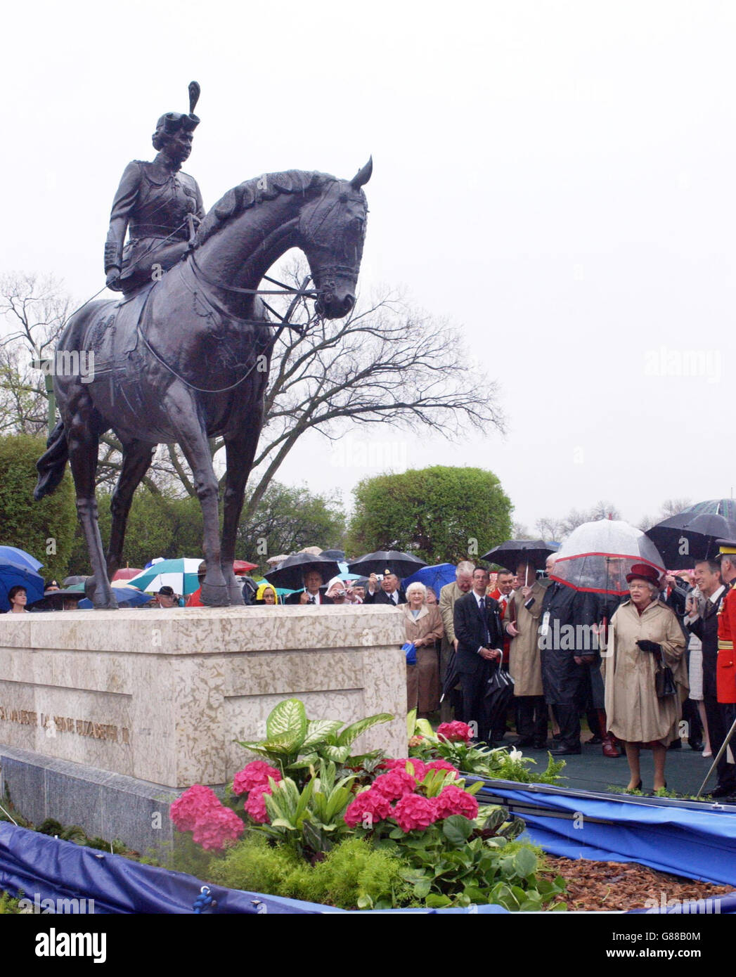 Queen Elizabeth II looks at a statue that she unveiled outside the ...