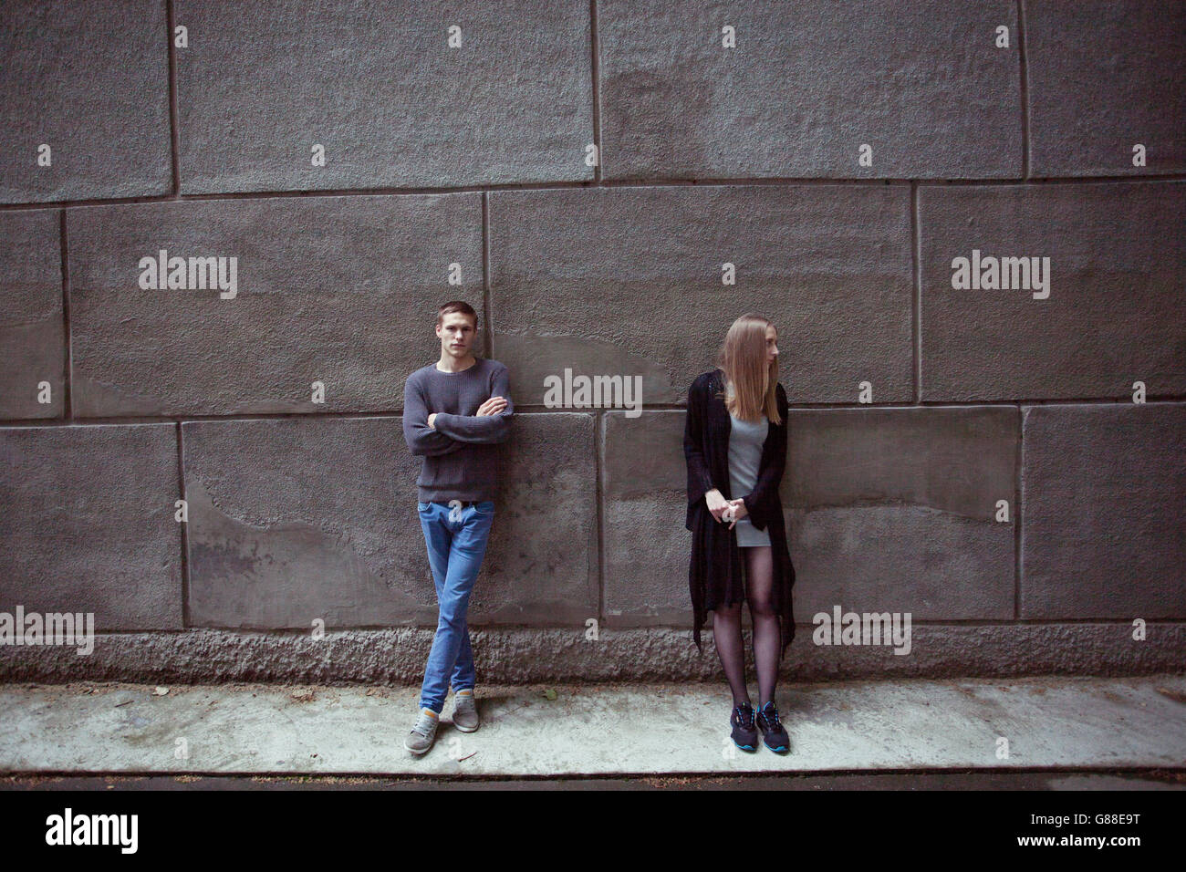 Woman Leaning Against Wall Arms Crossed High Resolution Stock ...