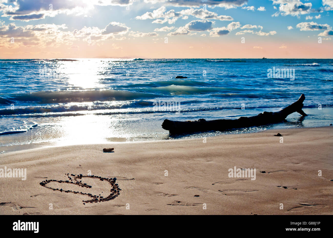 a heart waiting for you on the beach by the sea lit by the sunset Stock ...