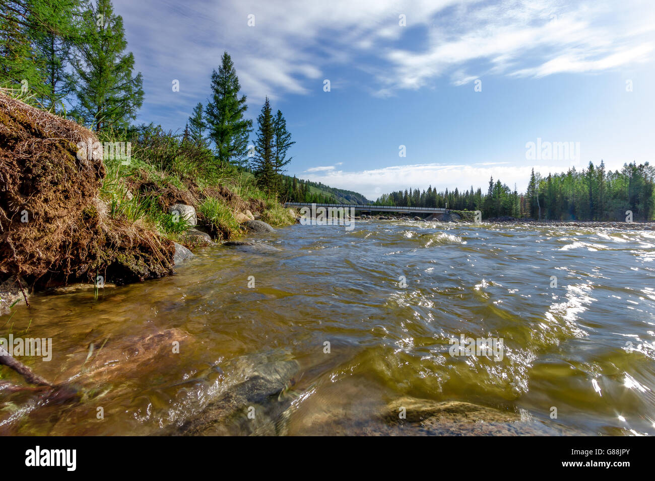 Small river with rocky shores flowing through a mountain valley Stock ...