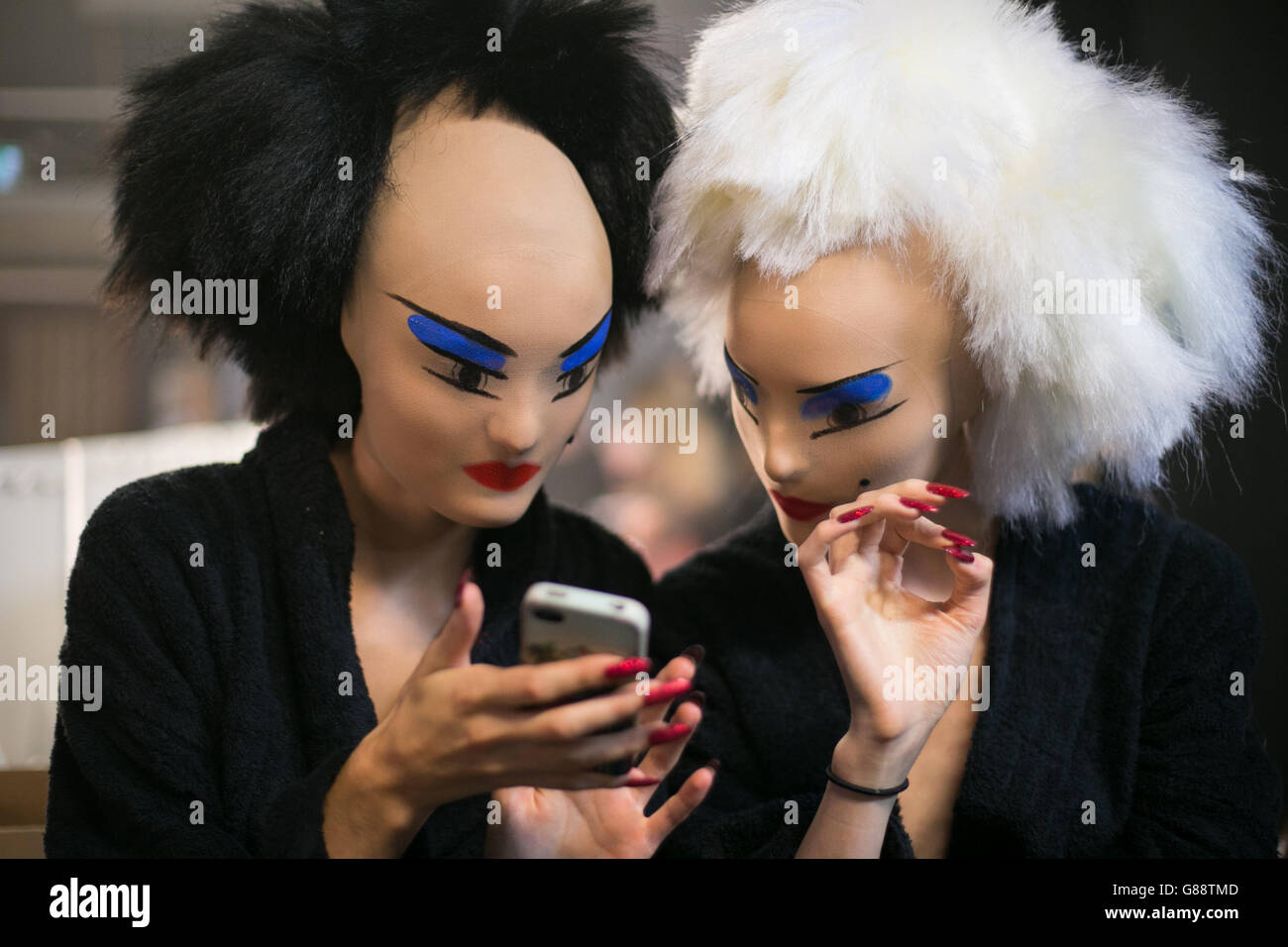 A model show pictures on a smartphone before the Gareth Pugh show ...