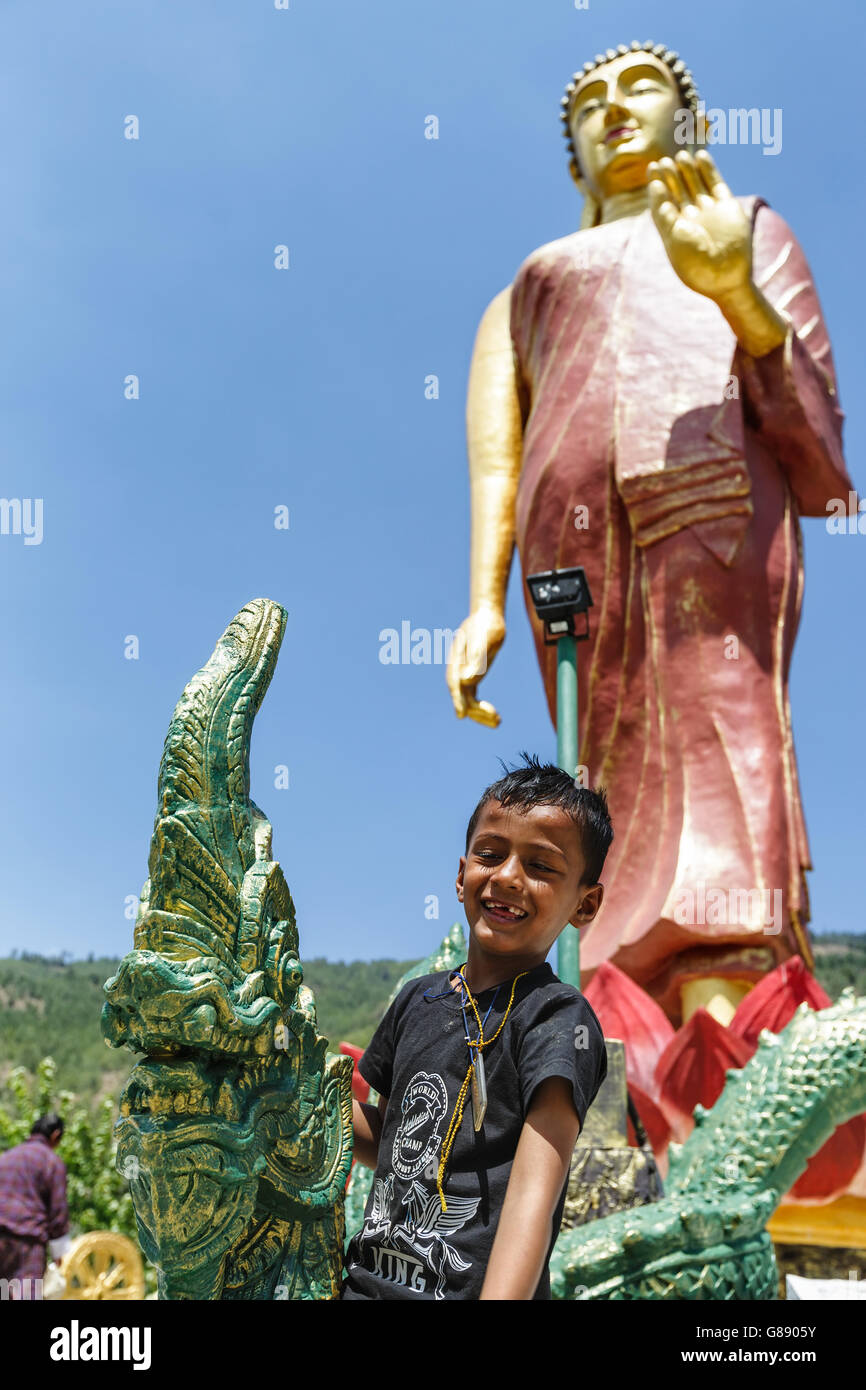 Boy rides dragon statue in front of Standing Buddha statue Stock Photo ...