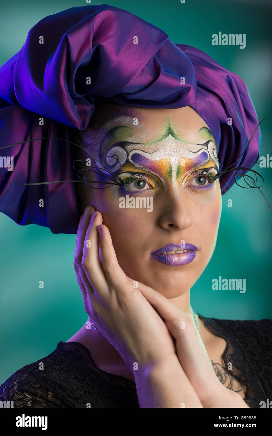 Female model portrait with tribal creative make-up swirl and purple ...