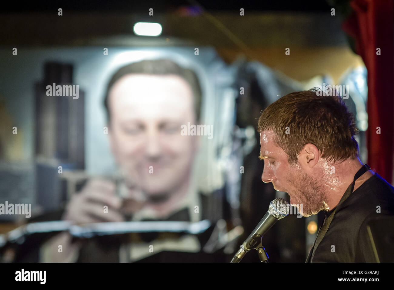 Sleaford Mods vocalist Jason Williamson performs on stage next to a ...