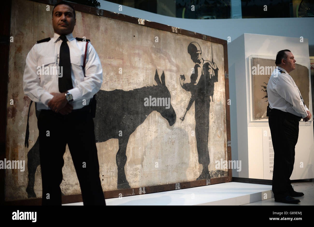 Security guards stand beside banksys donkey documents hi-res stock ...