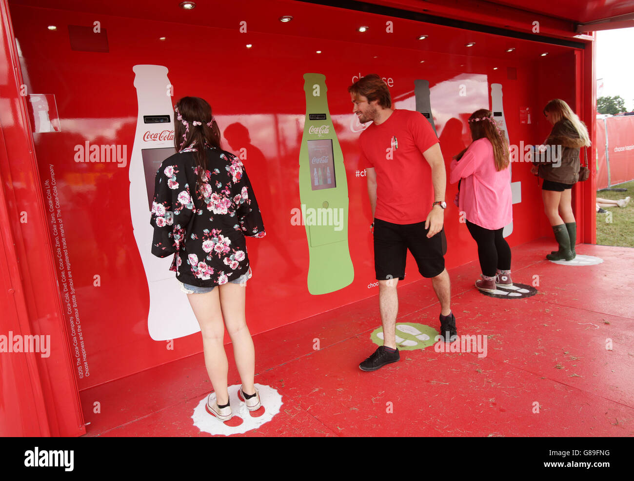 Festival goers receiving drinks in the Coca-Cola Share a Coke party pod ...