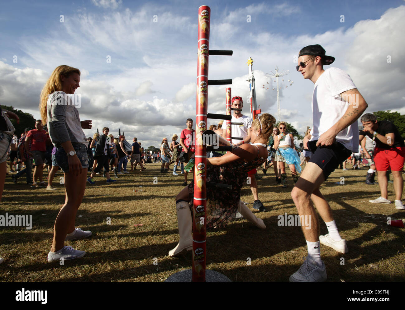 Festival goers limbo-dancing at the Pringles Party Tour area, at the V ...