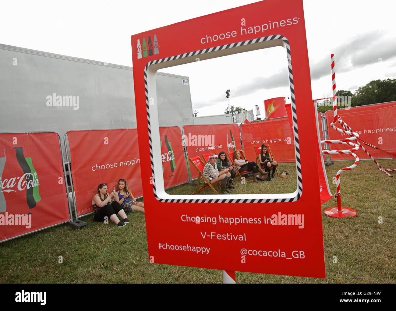 Festival goers enjoying drinks in the Coca-Cola Share a Coke party pod ...