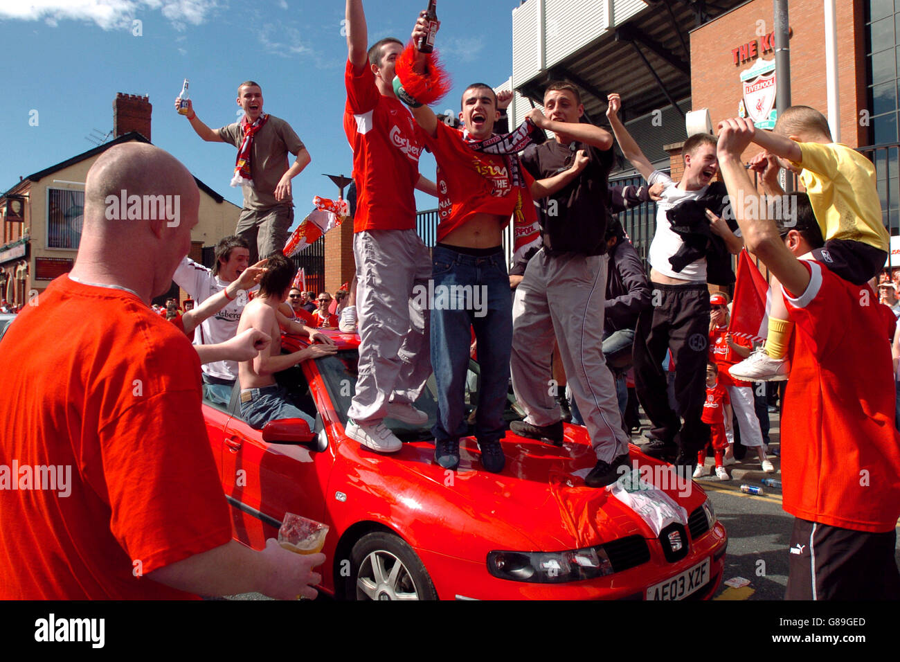 Liverpool fans celebrate in the street as they await the arrival of the ...