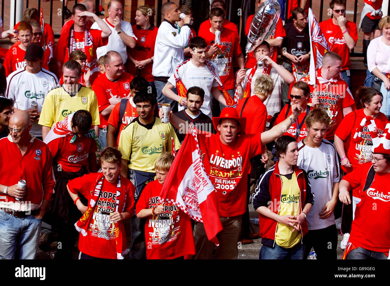 Liverpool fans celebrate in the street as they await the arrival of the ...