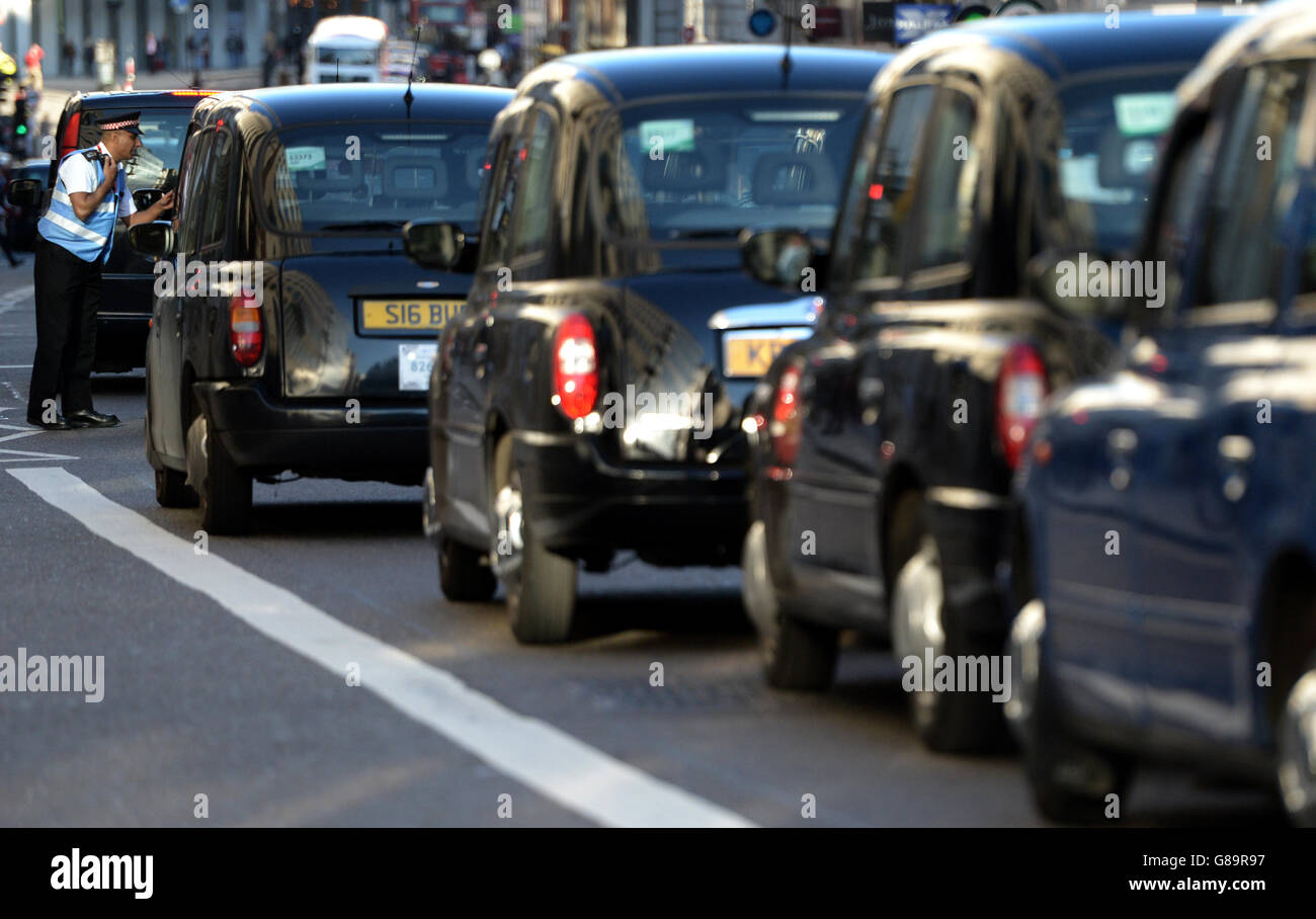 A traffic officer speaks to a driver as taxis line up on Fleet Street ...