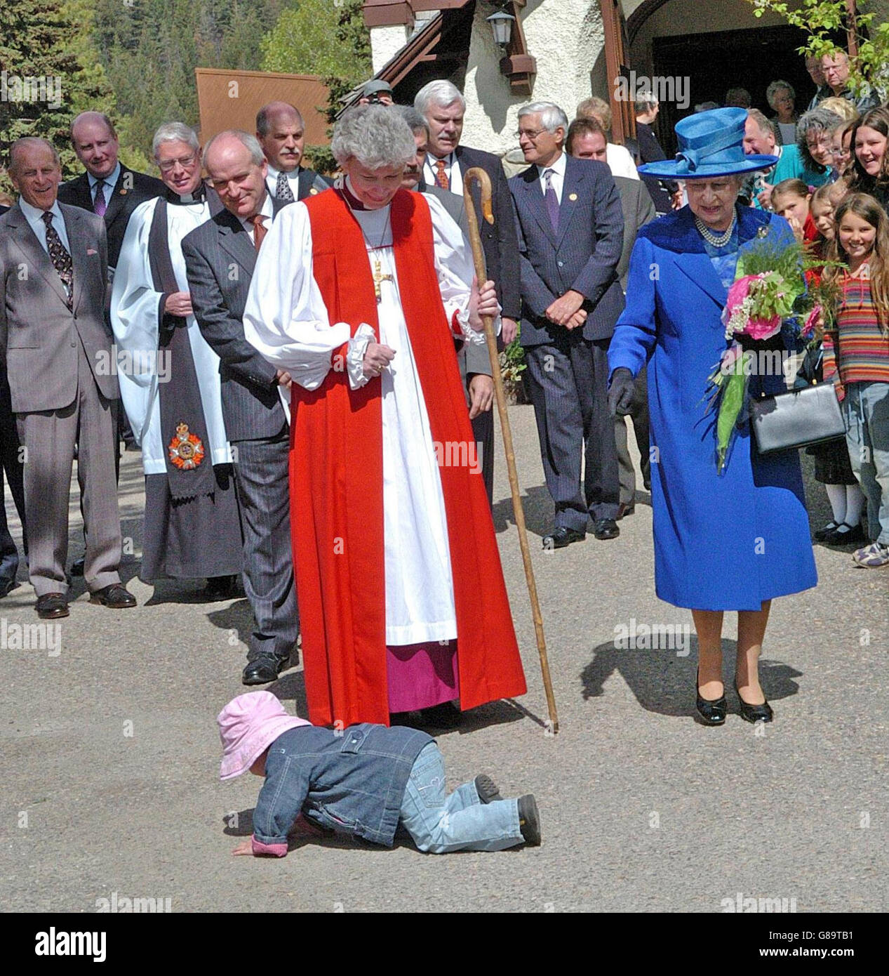 Two year old Brynn Noble crawls in front of Britain's Queen Elizabeth ...