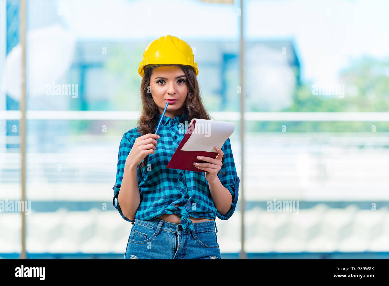 Woman builder taking notes at construction site Stock Photo - Alamy