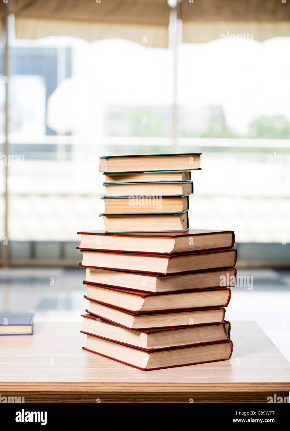 Stack of books arranged the office desk Stock Photo - Alamy