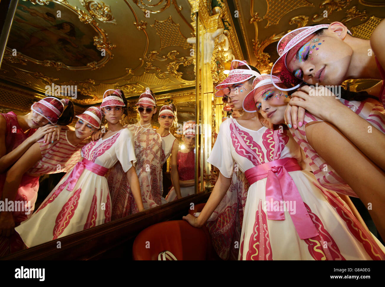 Models posing in front of a mirror with their reflections during the ...