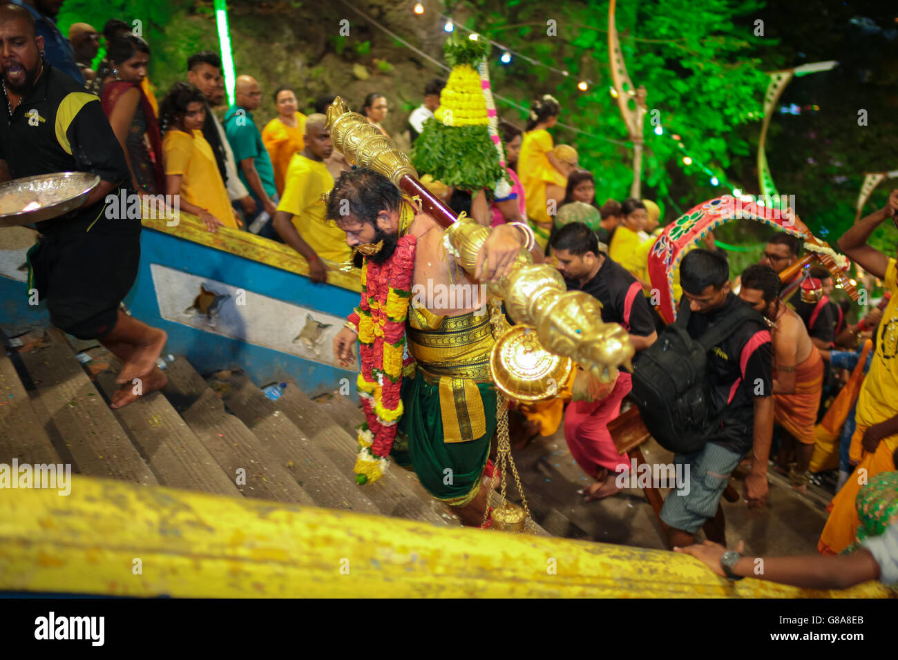 Hindu kavadi bearer carry heavy golden rod climb the stair to Batu Cave ...