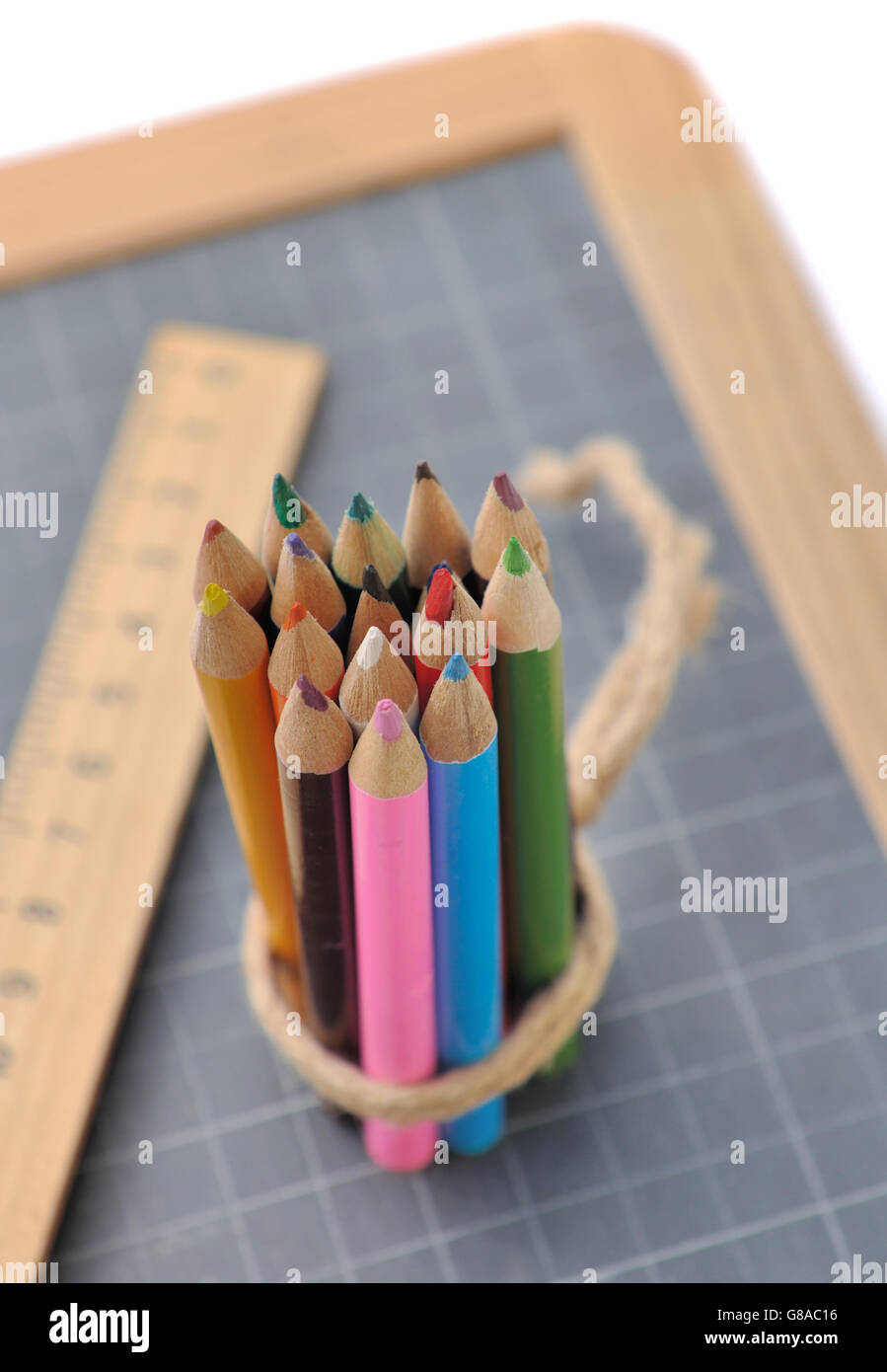 package of colored pencils with wooden rule on a slate Stock Photo - Alamy