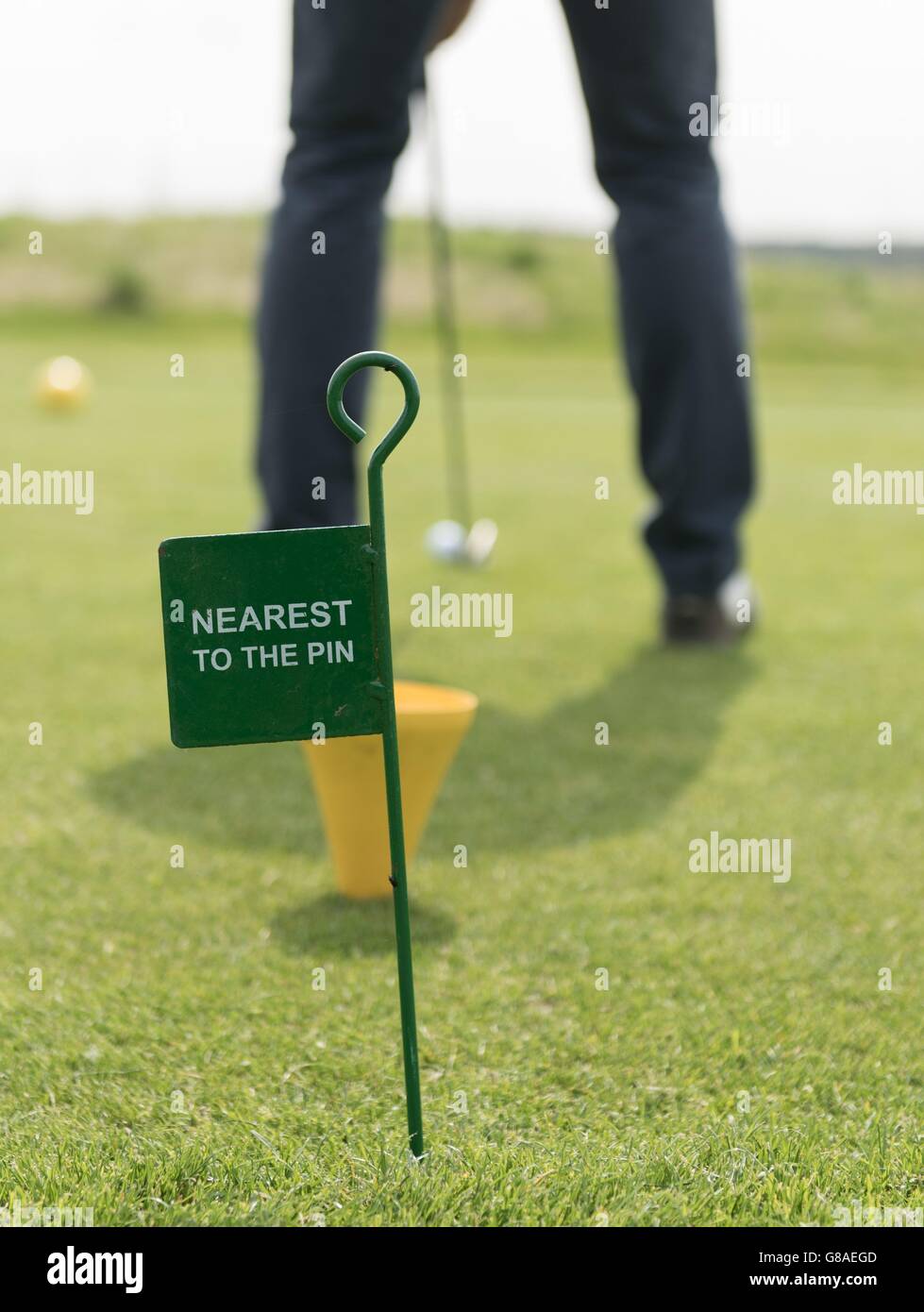 sign "nearest to the pin" with player in background, putting | usage ...