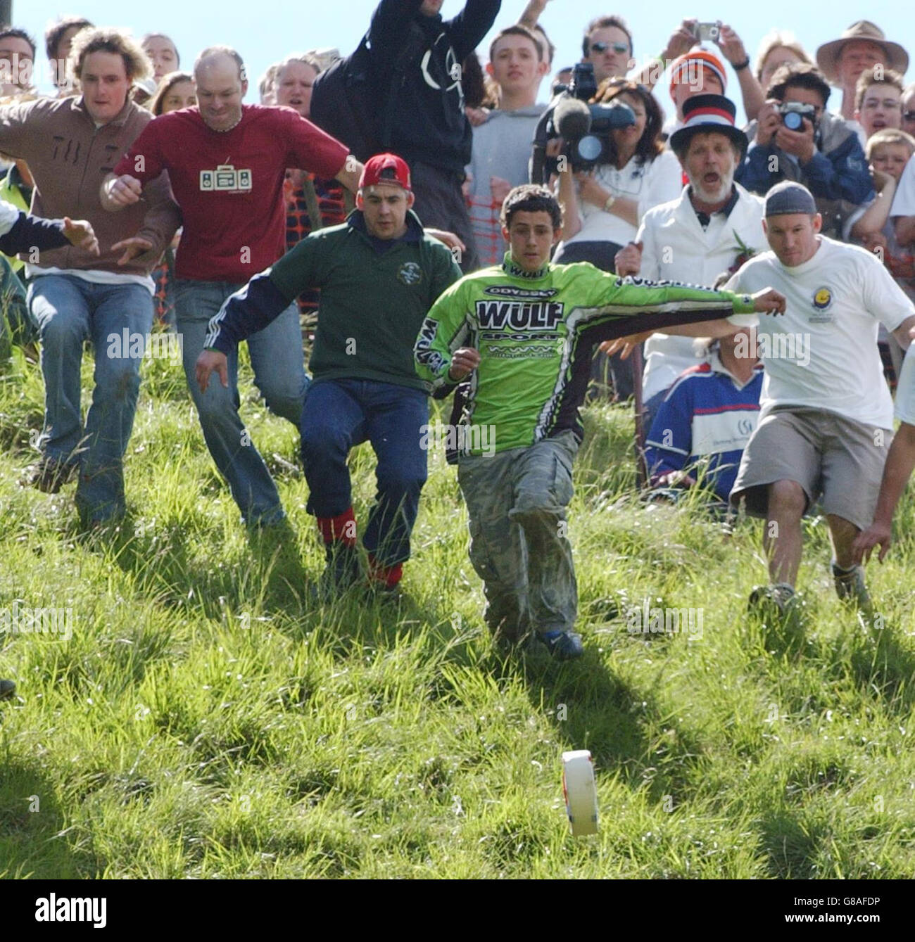 Competitors chase a Double Gloucester cheese down a steep slope, for ...