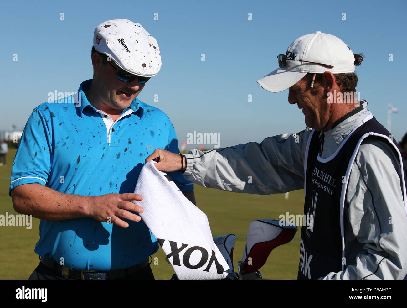 Scotland's Chris Doak cleans up after playing a shot out of the Swilken ...