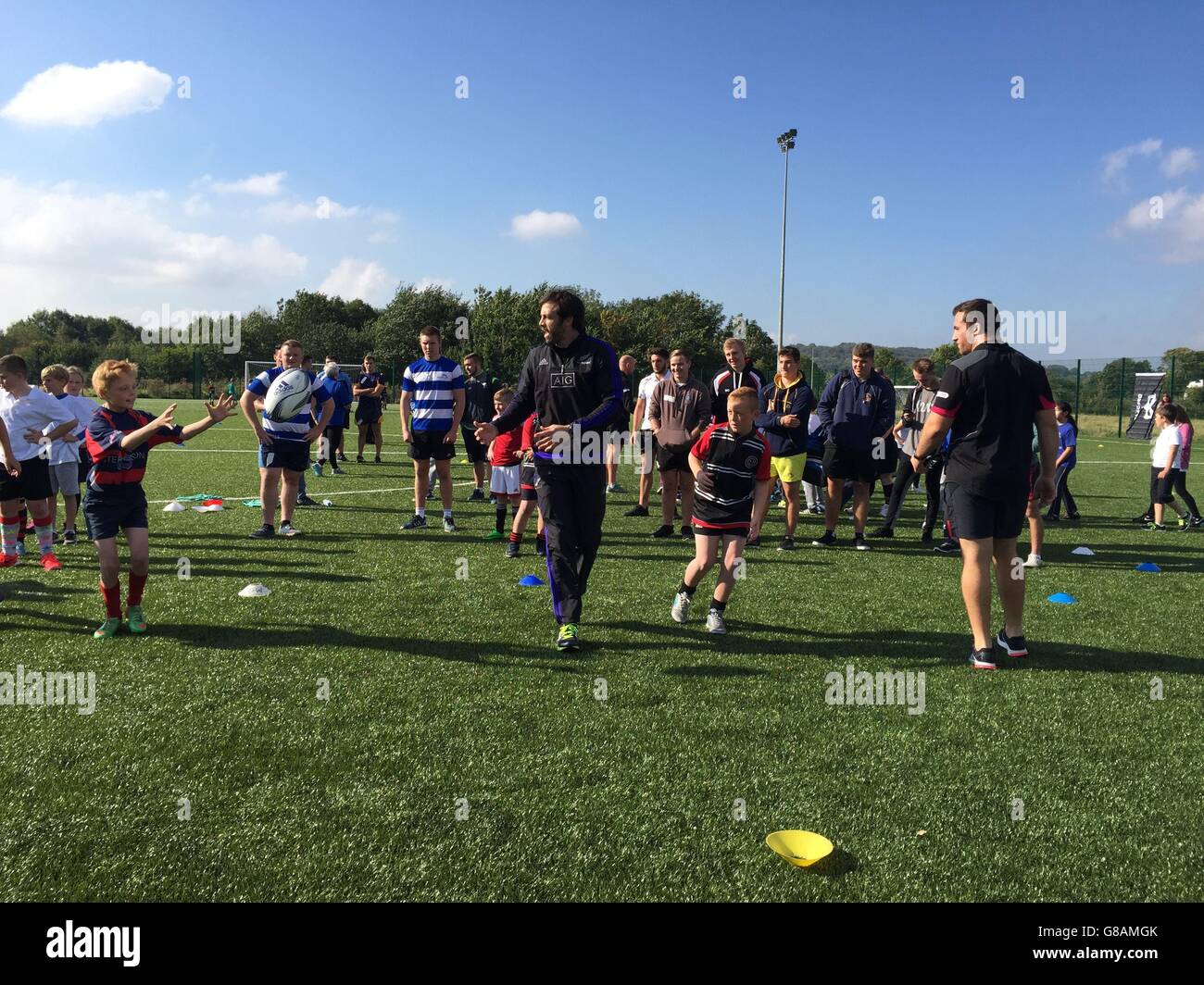 New Zealand rugby international Conrad Smith passes the ball to a boy ...