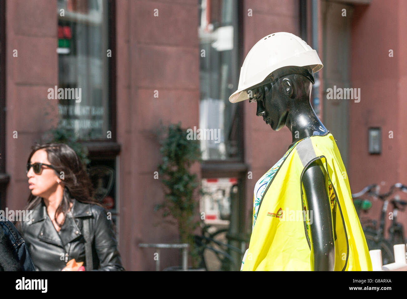 Black fashion dummies standing in the street, one dummy with safety ...