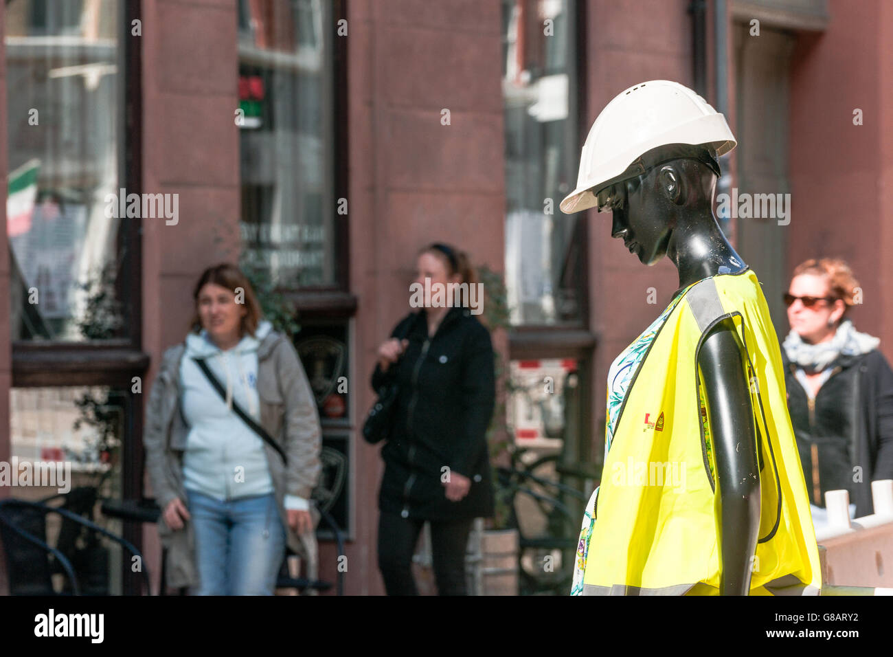Black fashion dummies standing in the street, one dummy with safety ...