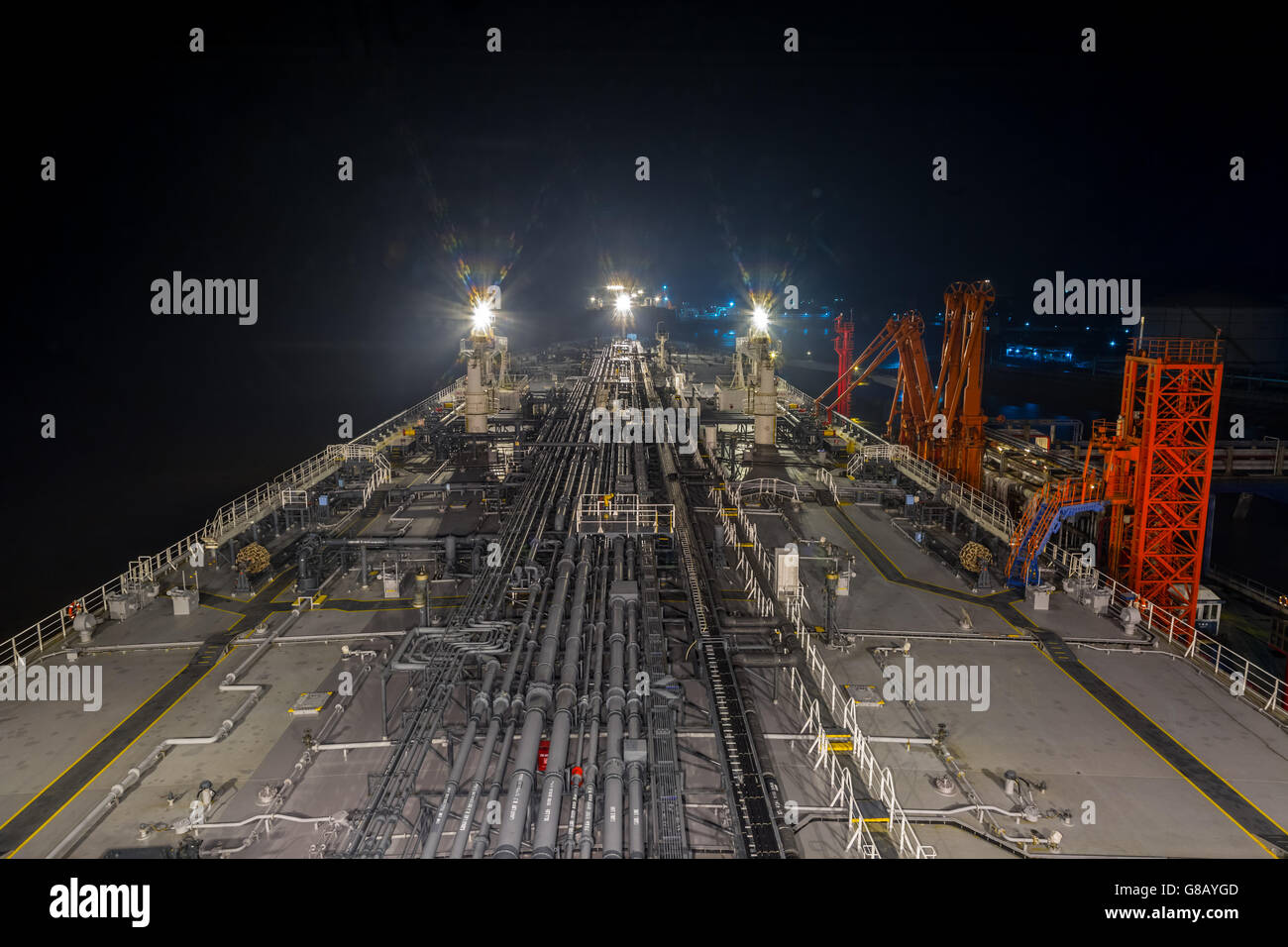 Big oil tanker moored to hte berth at night and ready to transfer the ...