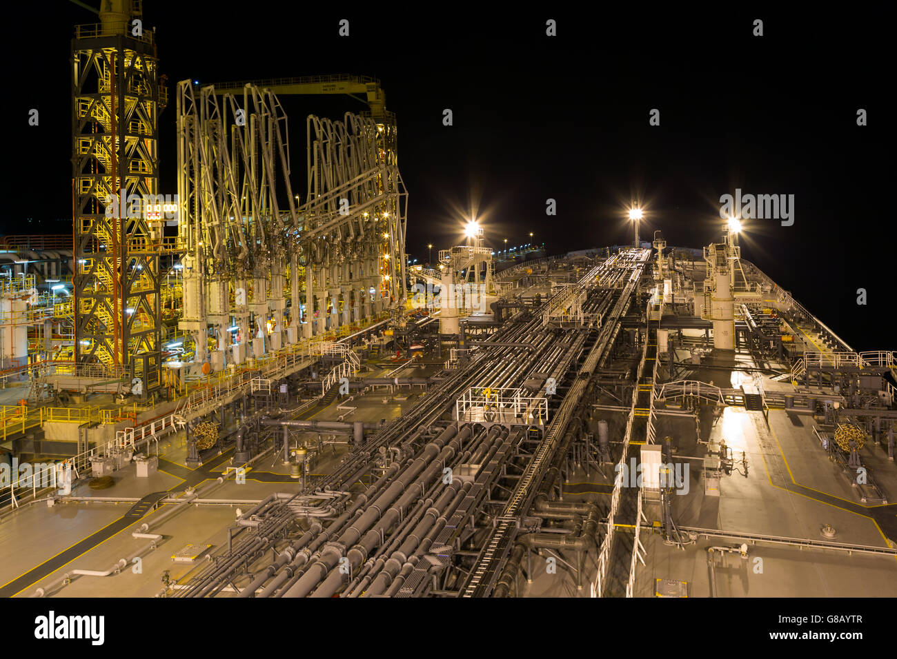 Oil transfer terminal with moored to the berth tanker at night Stock ...