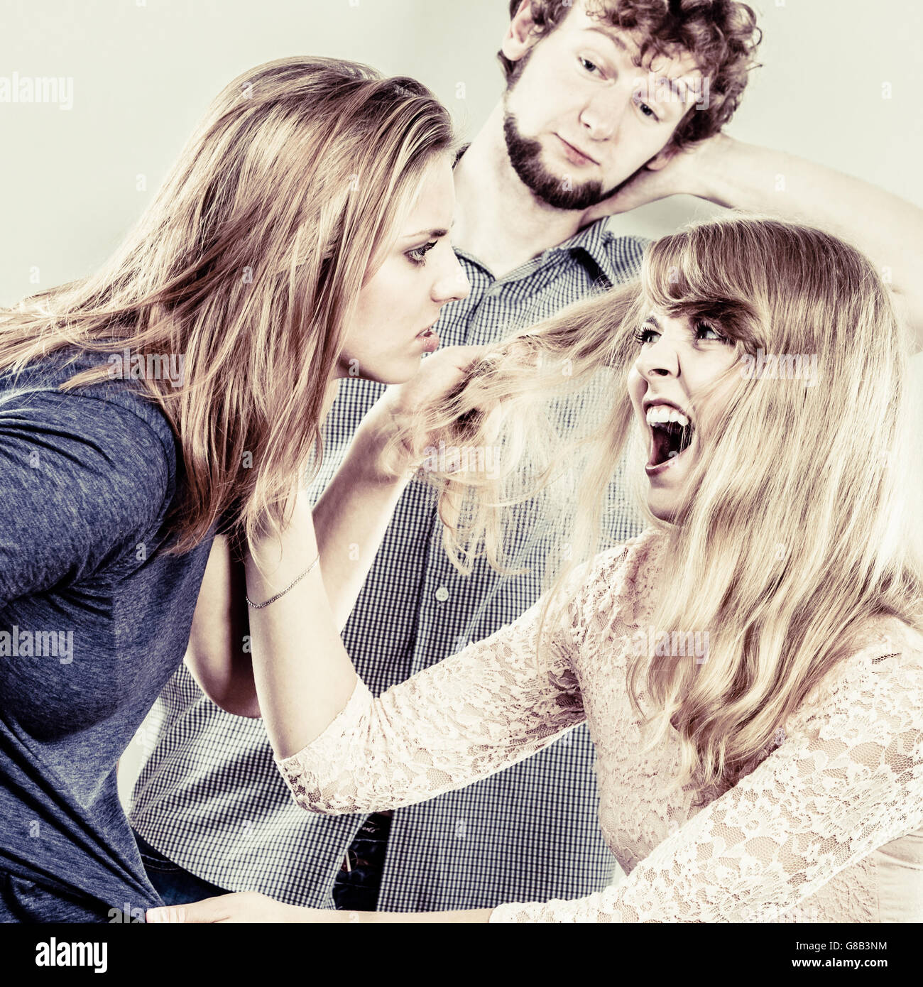 Aggressive mad women fighting over man. Young jealous girls wooing guy ...